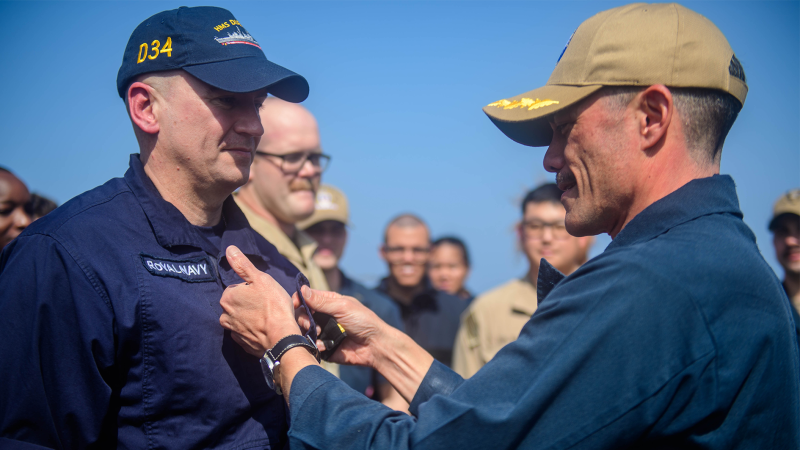 Royal Navy officer promoted by US Navy man on board US Navy destroyer ...